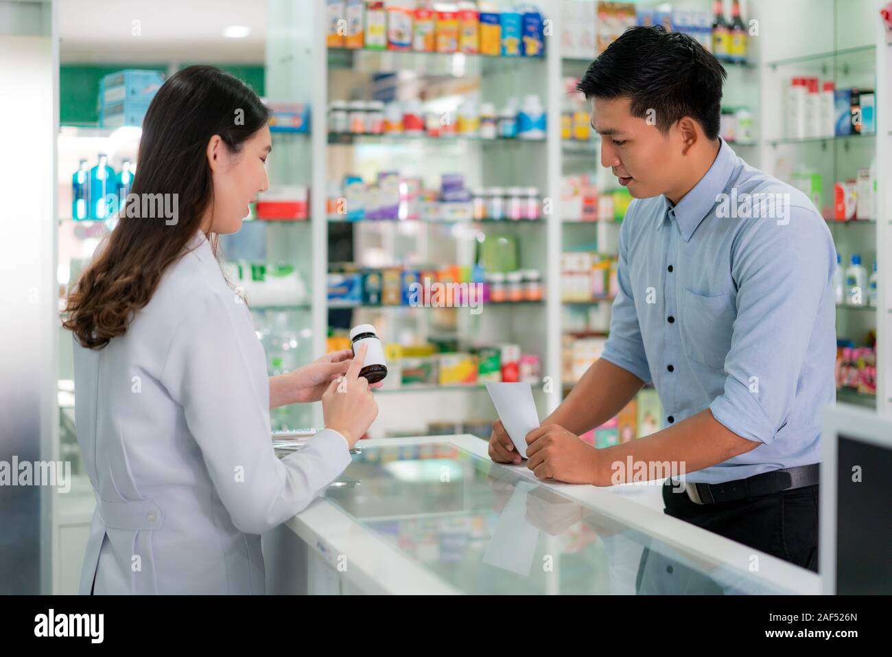 Confident Asian young female pharmacist with a lovely friendly smile ...