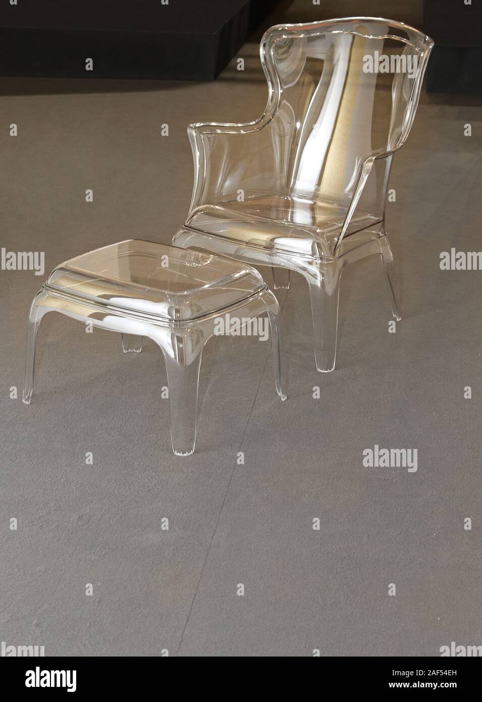 Modern transparent armchair and stool in studio Stock Photo - Alamy