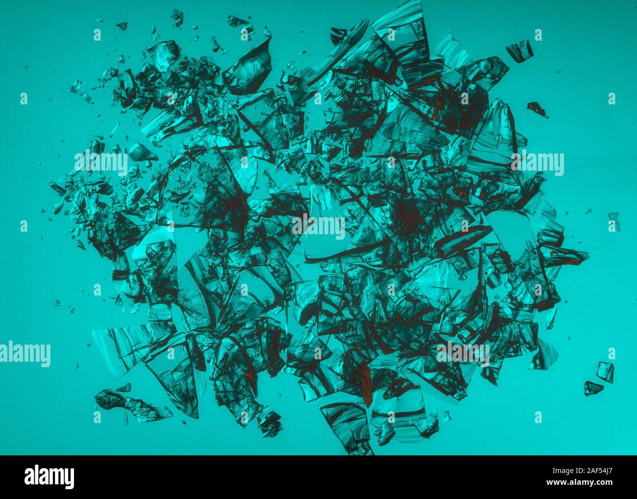 Small glass fragments on a turquoise background Stock Photo - Alamy