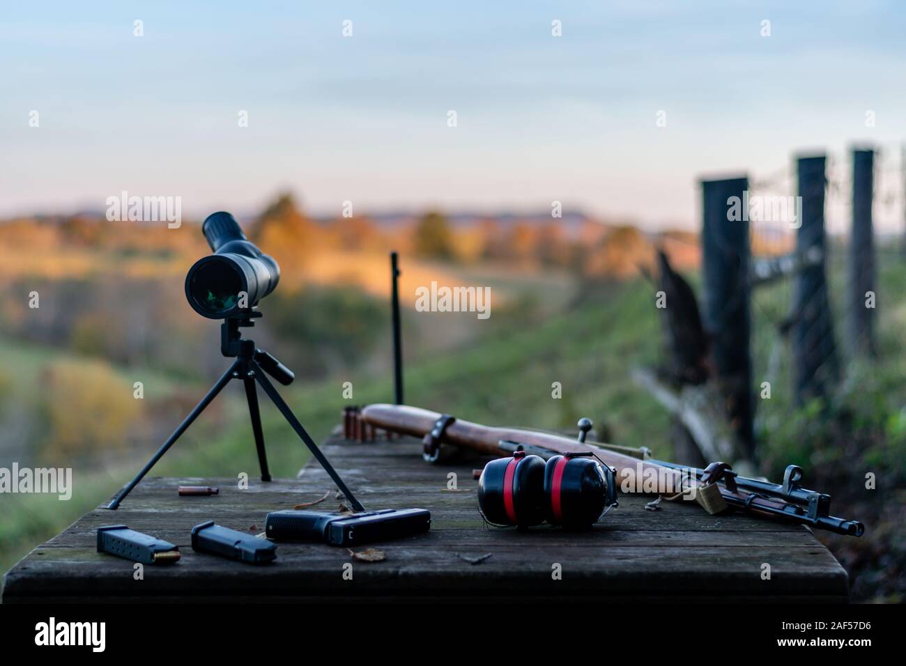 guns on table. spotting scope hearing protection handgun/pistol and old ...