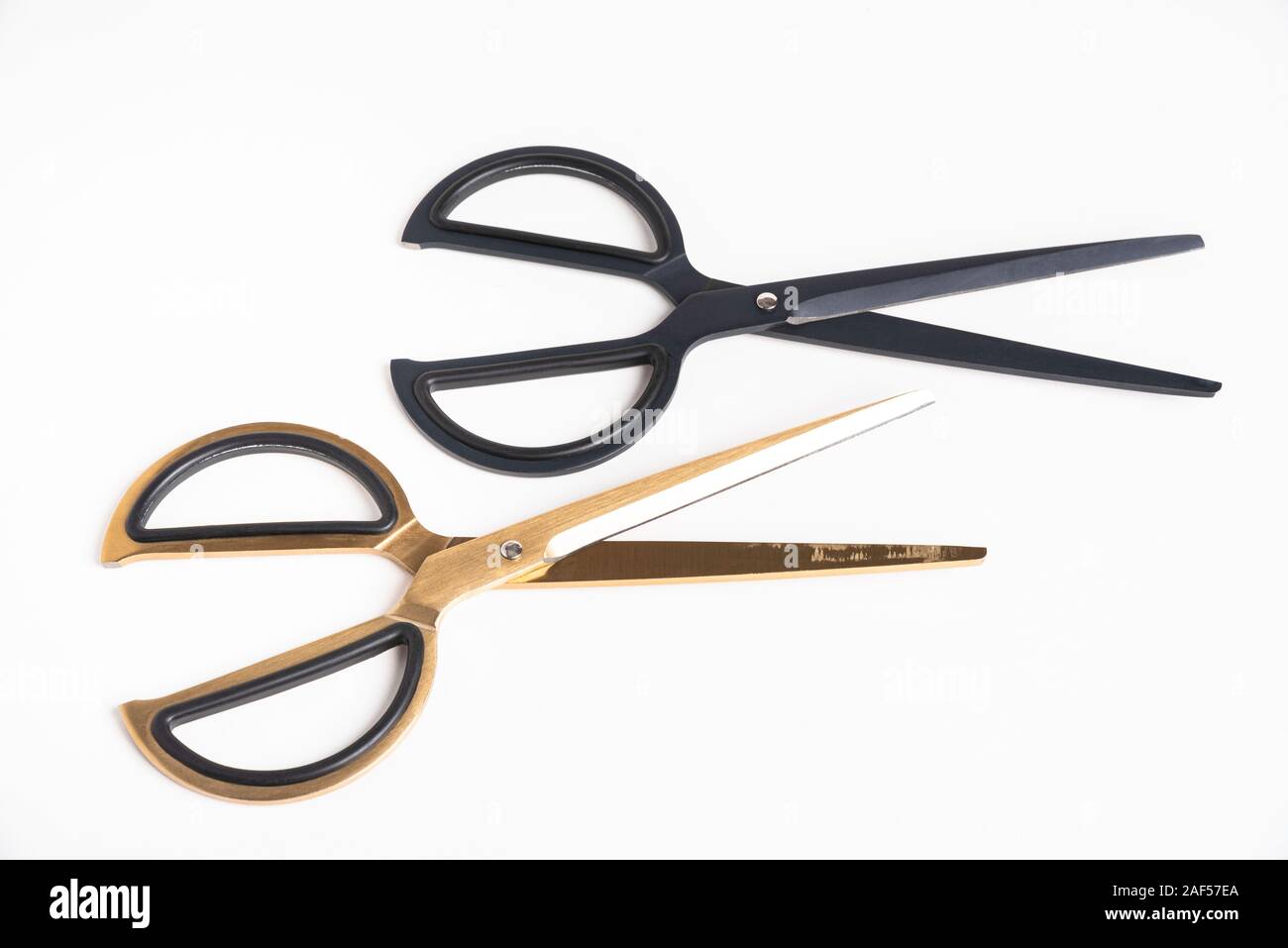 Two pairs of retro or vintage style scissors in black and gold set on a ...