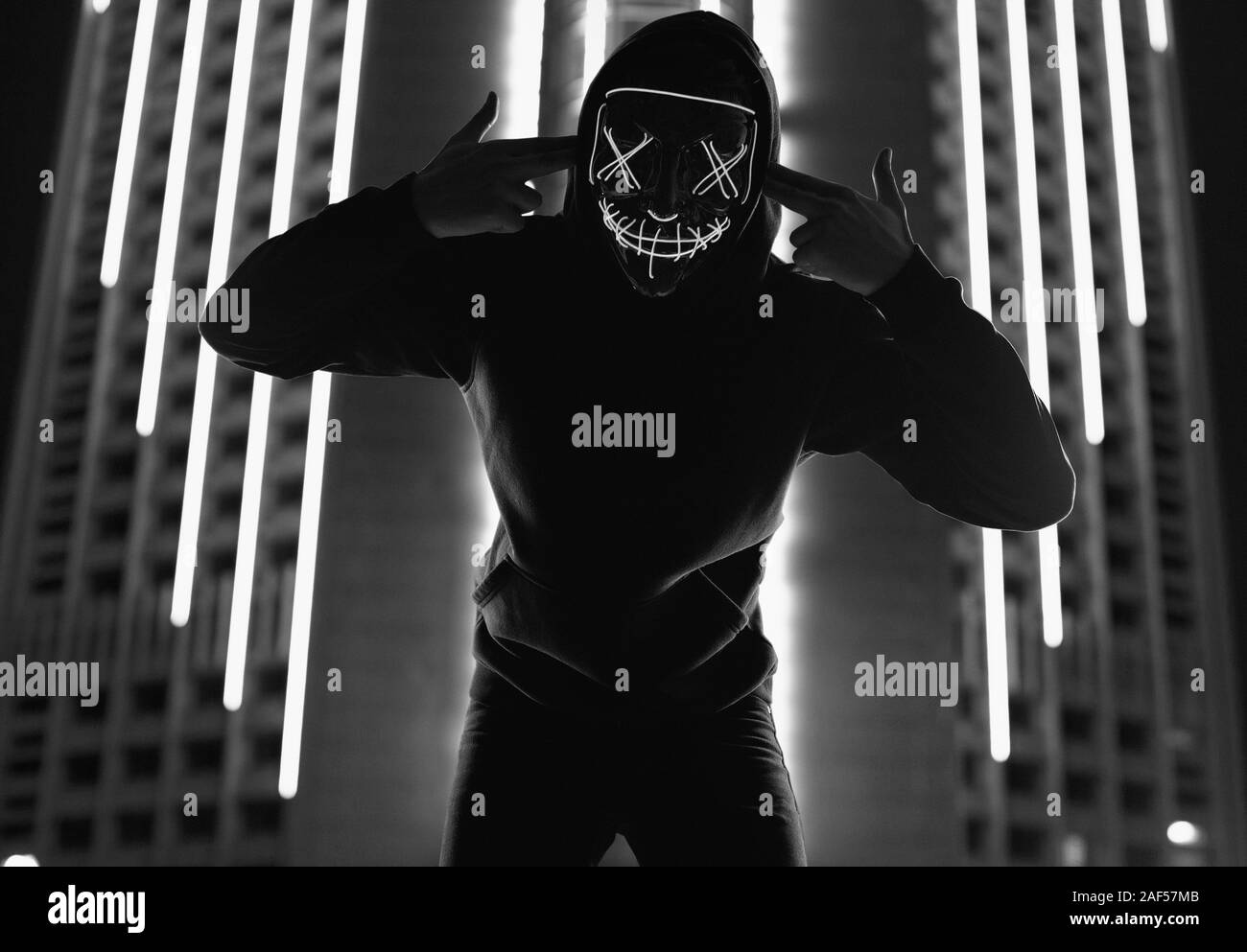 Portrait of an anonymous man in a black hoodie hiding his face behind a ...