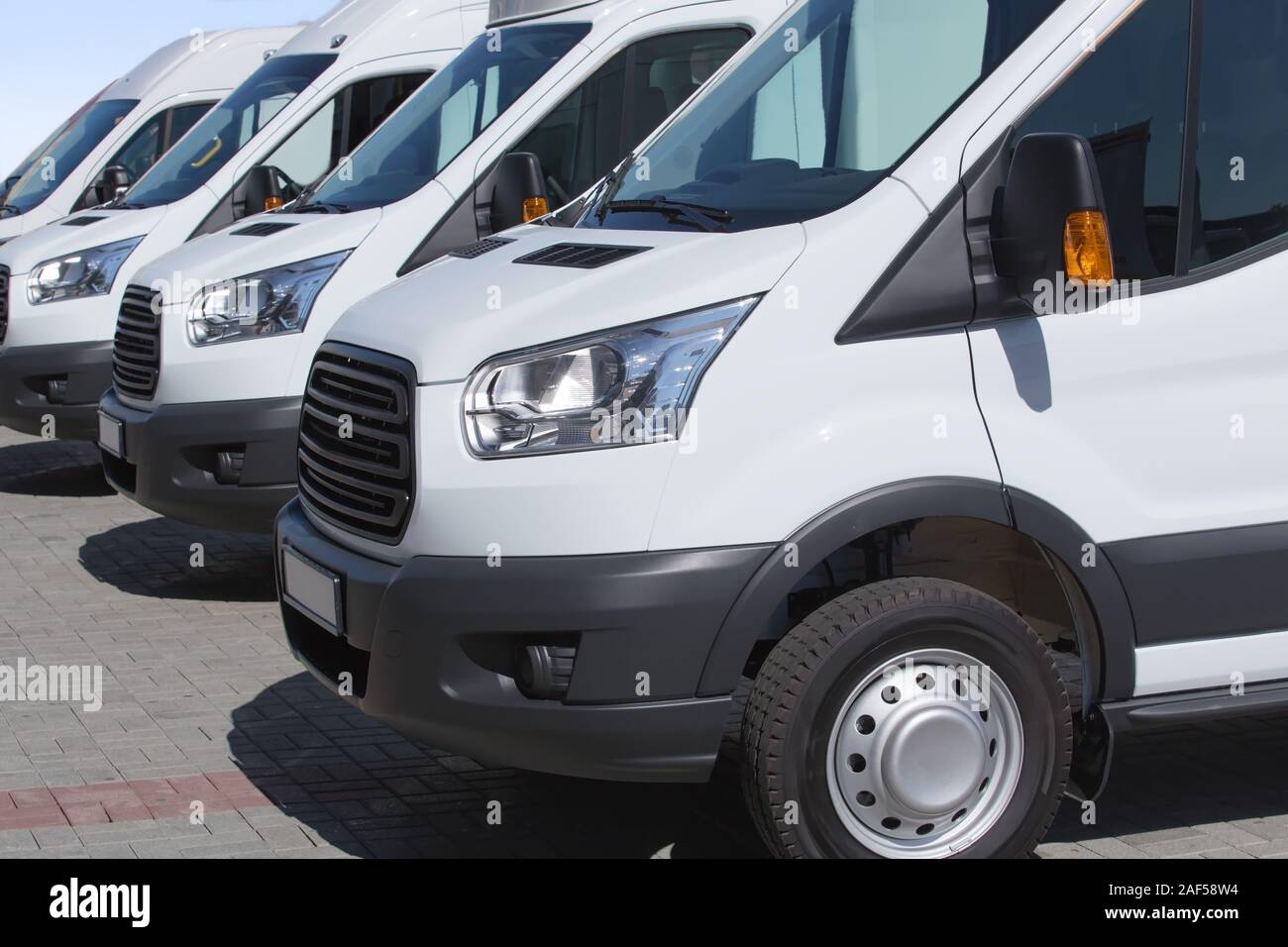 number of new white minibuses and vans outside Stock Photo - Alamy