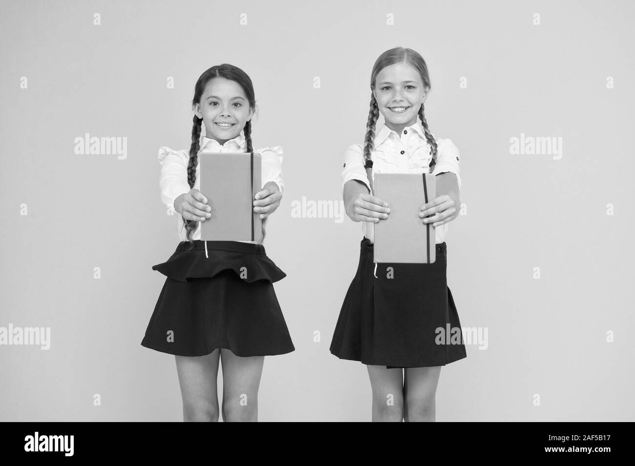 Sharing book love. Happy little girls holding books with colorful ...