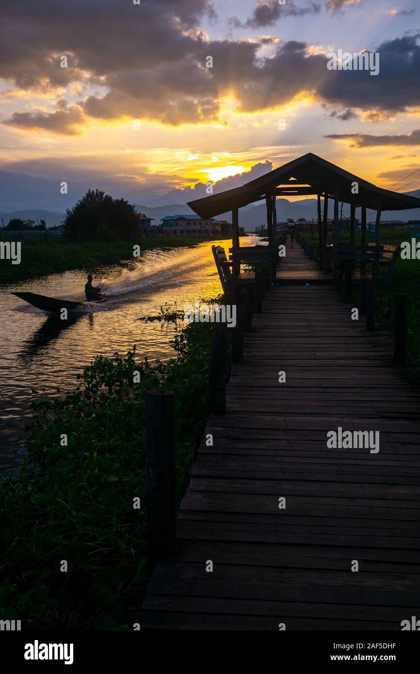 A boat travels down the canal next to the long wooden bridge at Maing ...