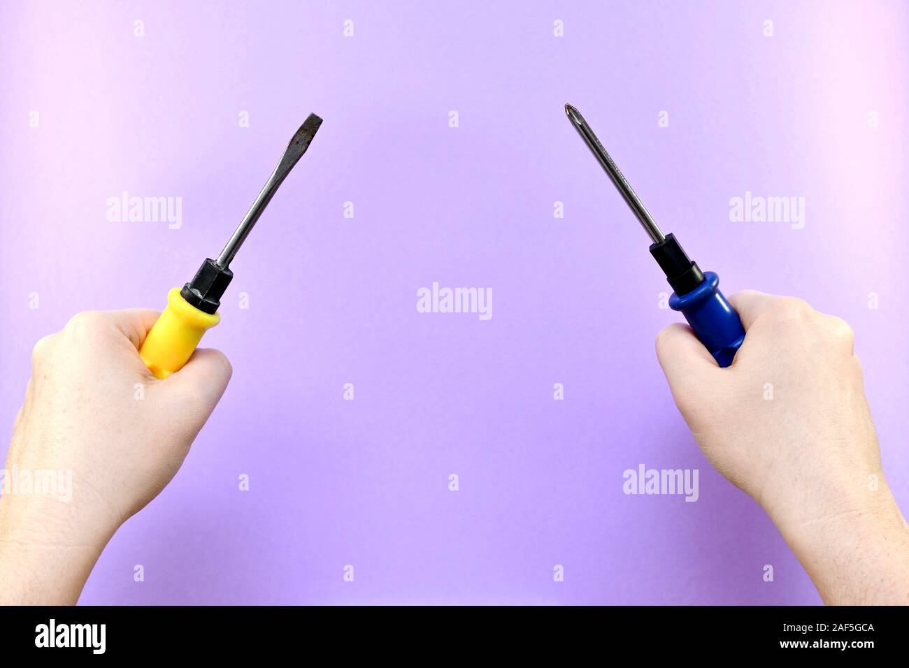 Two hands with a screwdriver in each, ready to go Stock Photo - Alamy