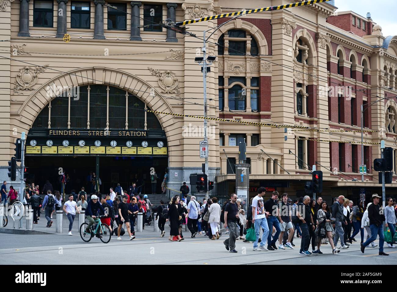 Pedestrians crossing Flinders Street, with the iconic Flinders Street ...