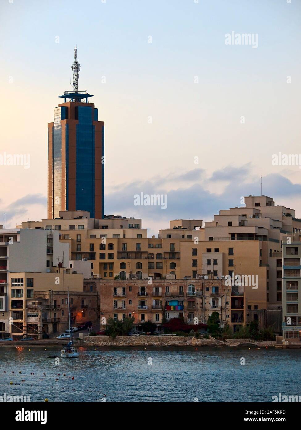 Old block of apartments on the seafront in Malta overshadowed by a ...