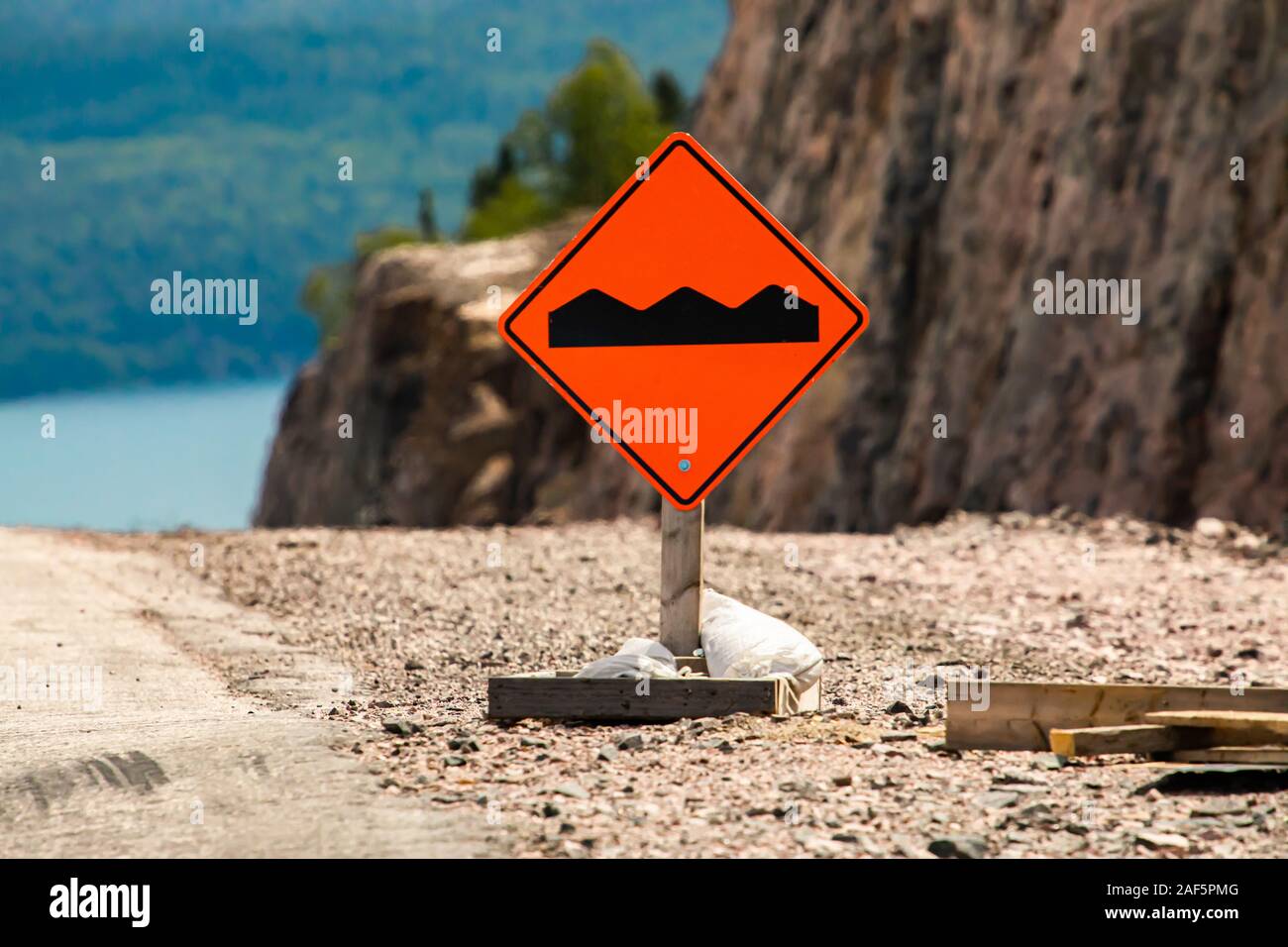 Bump or uneven pavement on the road ahead orange sign on the ground in ...