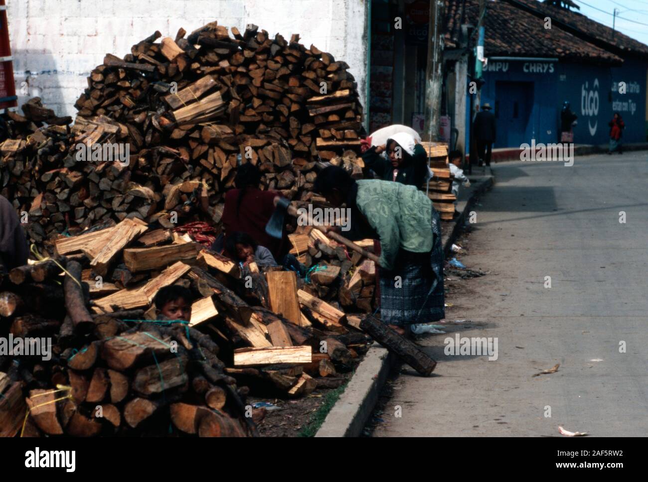An ethnic, indigenous Kiche Maya women chopping firewood in ...
