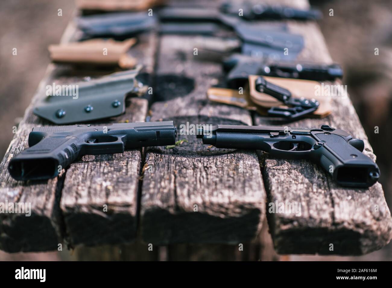 Black gun on brown table hi-res stock photography and images - Alamy