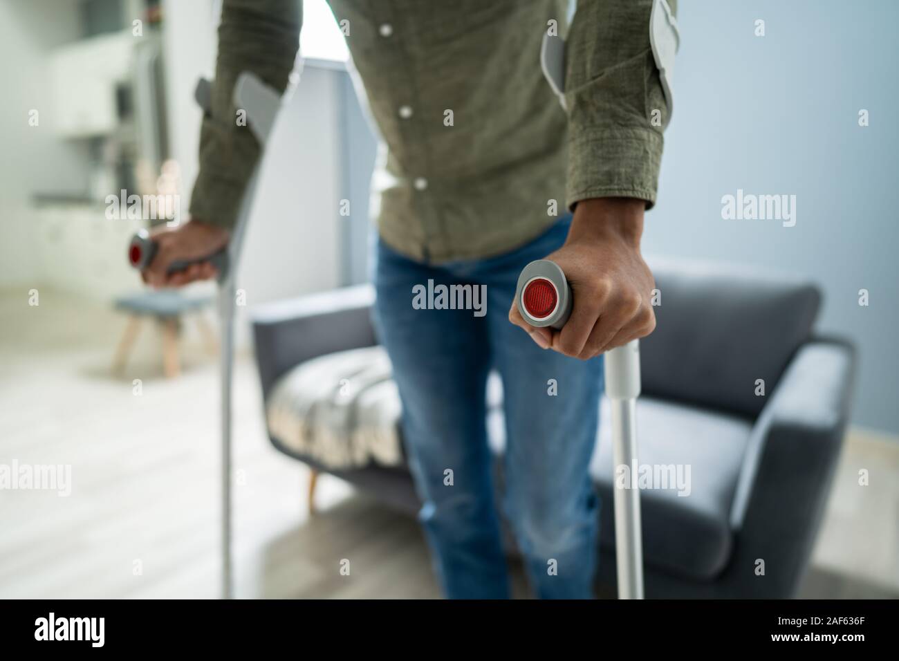 Disabled Man Using Crutches For Walking On Floor Stock Photo - Alamy