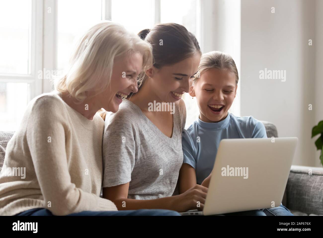 Three generations of women have fun watching video on laptop Stock ...