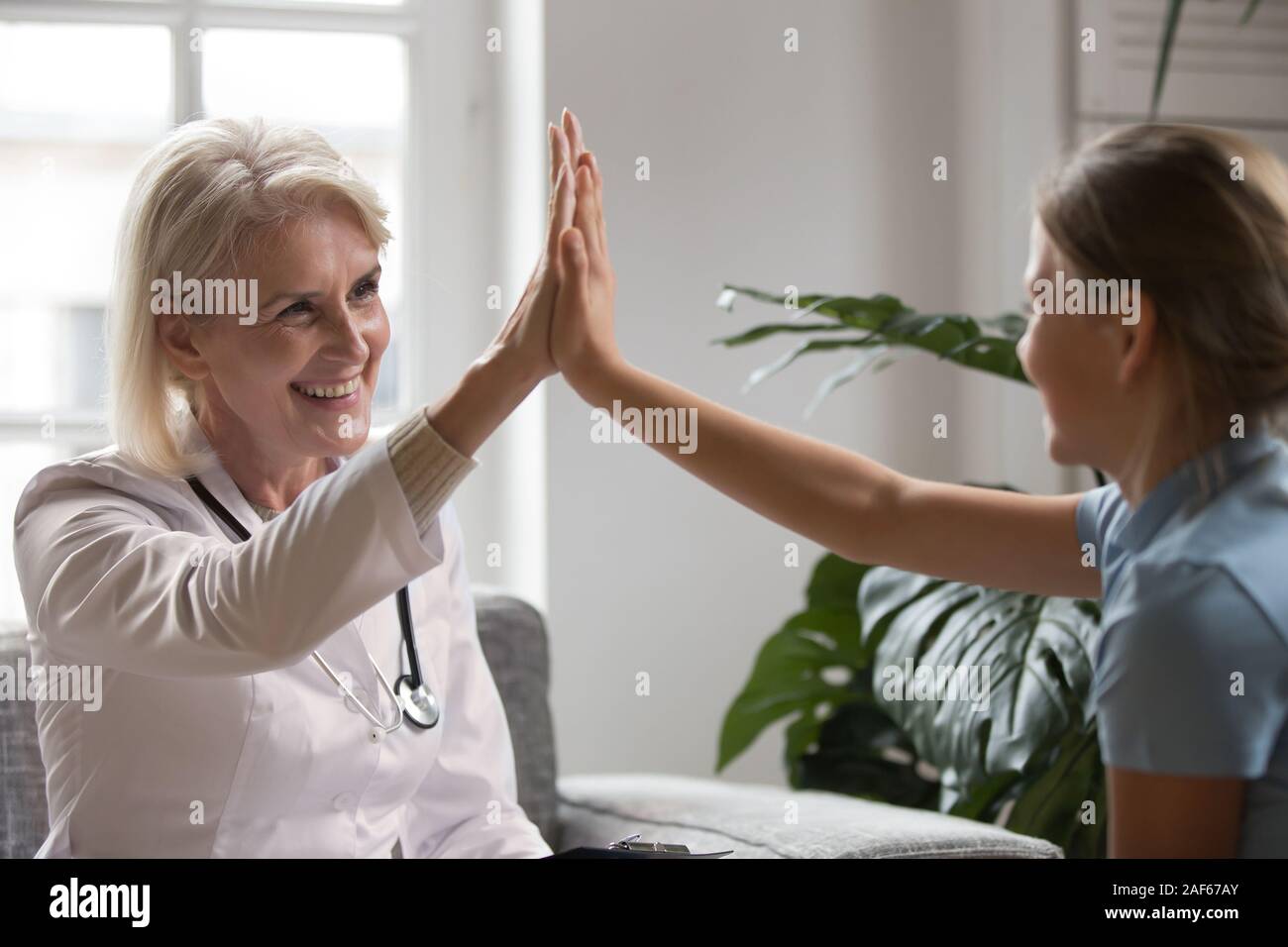 Smiling senior doctor celebrate good treatment with child patient Stock ...