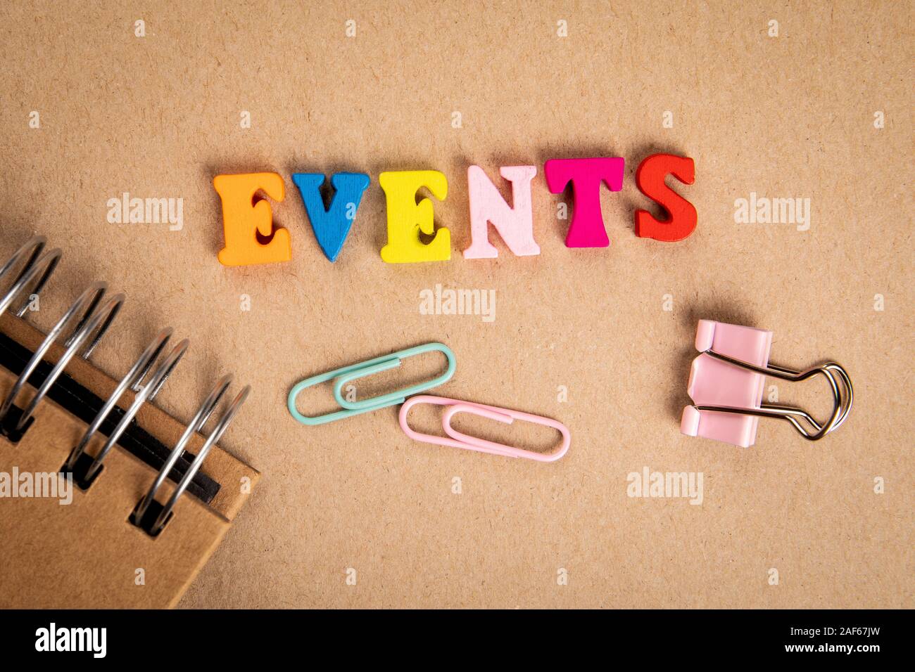 Events. Text from colorful wooden letters on cardboard background Stock ...