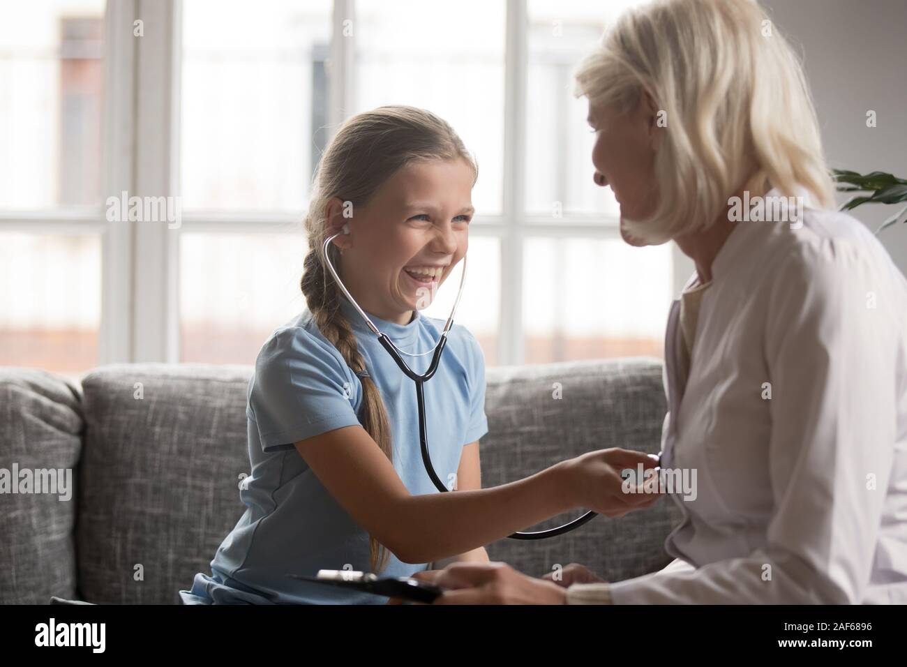 Smiling girl wear stethoscope play with doctor at home Stock Photo - Alamy