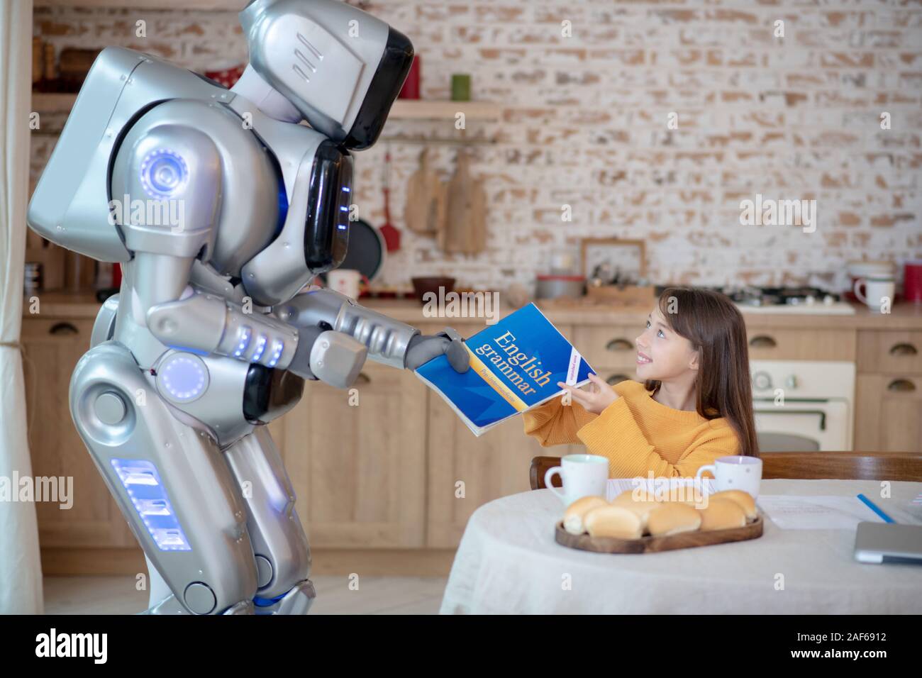 Robot giving english grammar book to a girl Stock Photo - Alamy