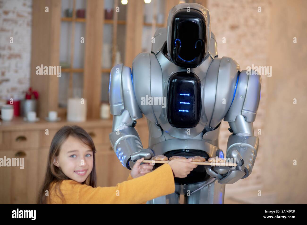 Cute blue-eyed girl demonstrating meat balls made by house robot Stock ...