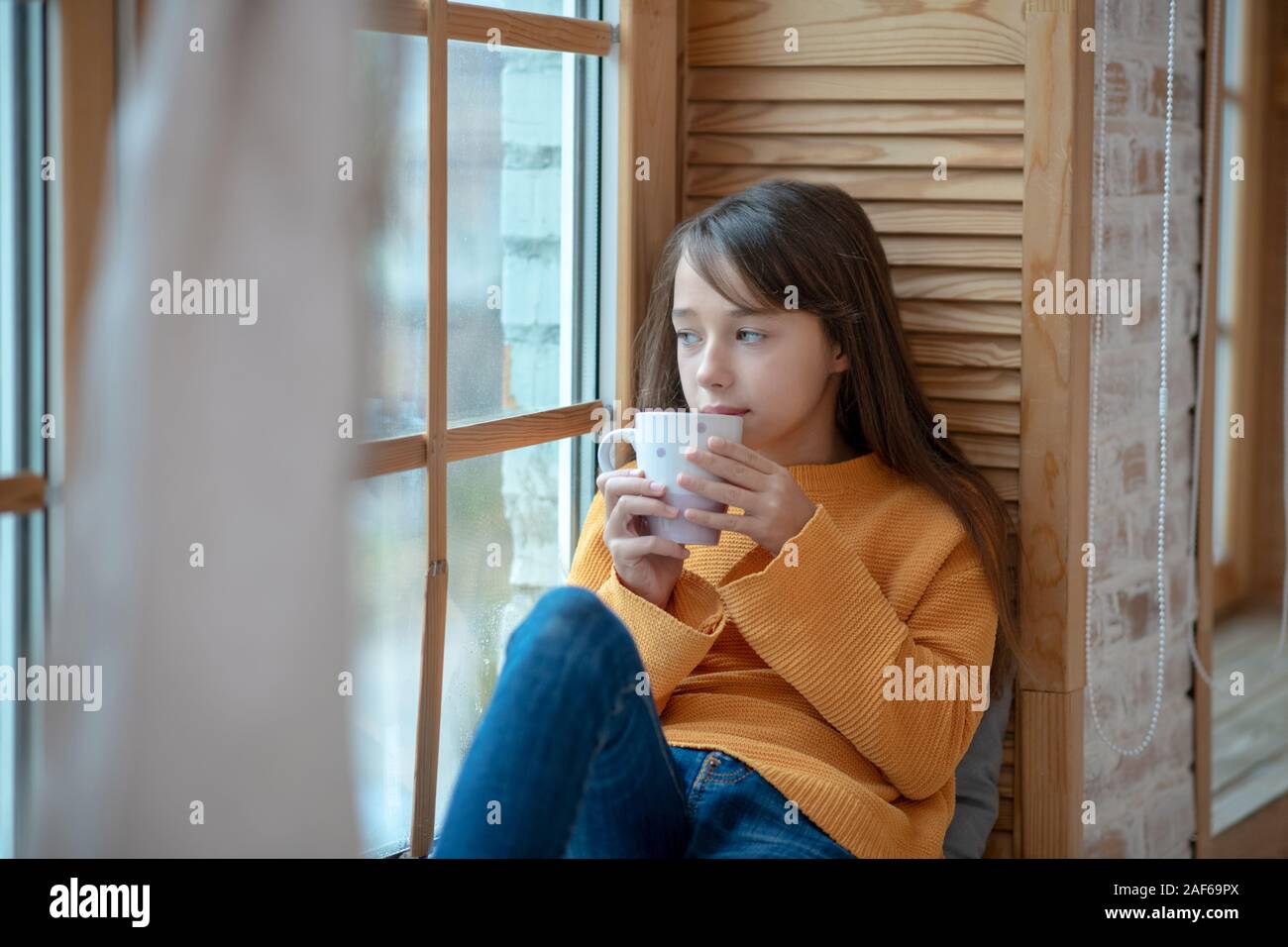 Cute girl looking out the window in the kitchen Stock Photo - Alamy