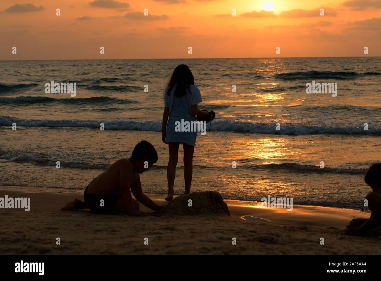 Children Playing And Looking Out At Sunset Over Ocean Stock Photo - Alamy