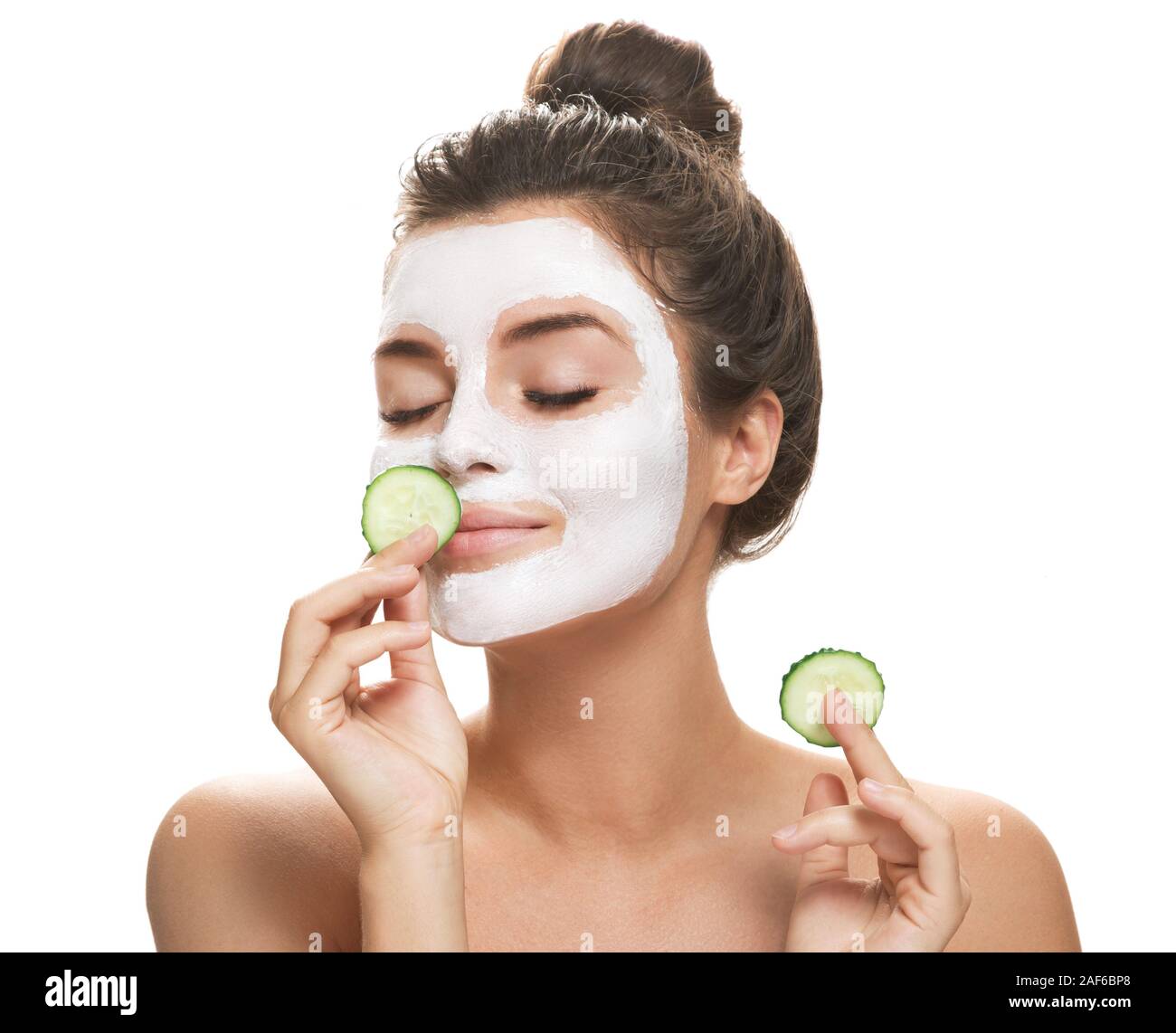 Woman with facial mask and cucumber slices in her hands on white ...