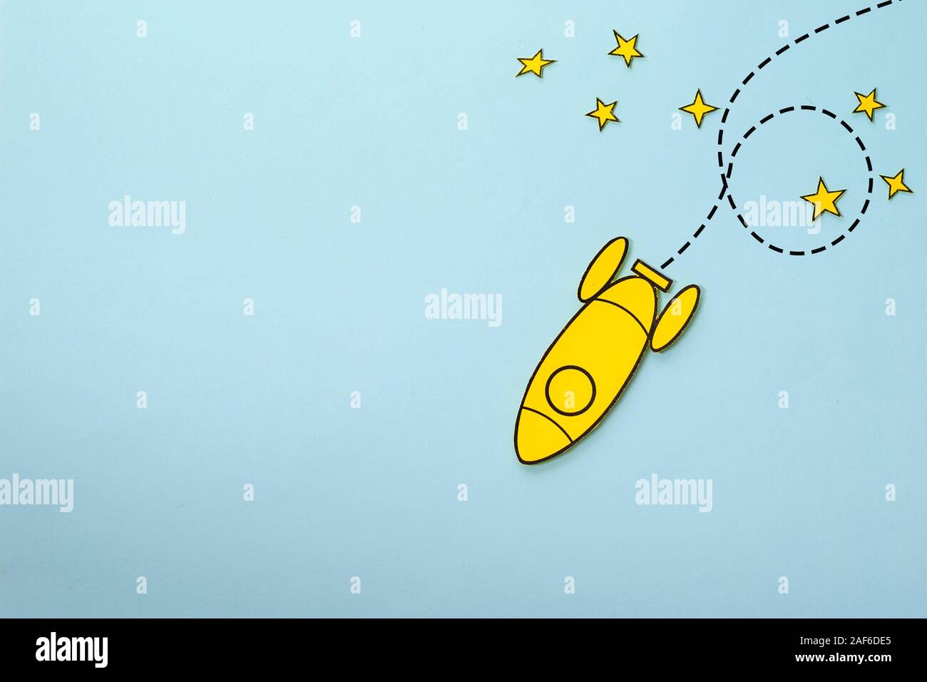 Little yellow rocket looping around stars over a blue background Stock ...