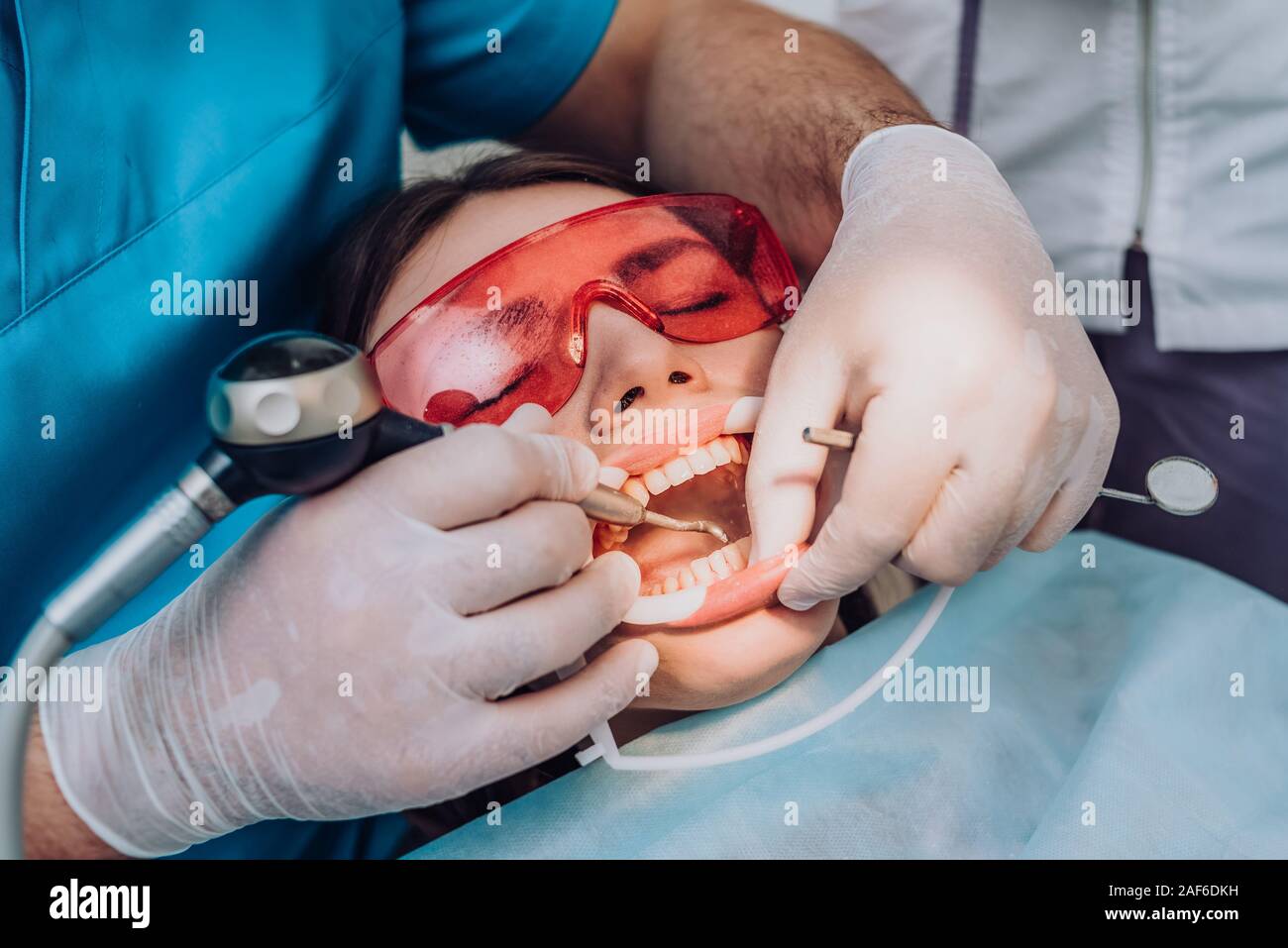Dentist performs teeth cleaning procedure hi-res stock photography and ...
