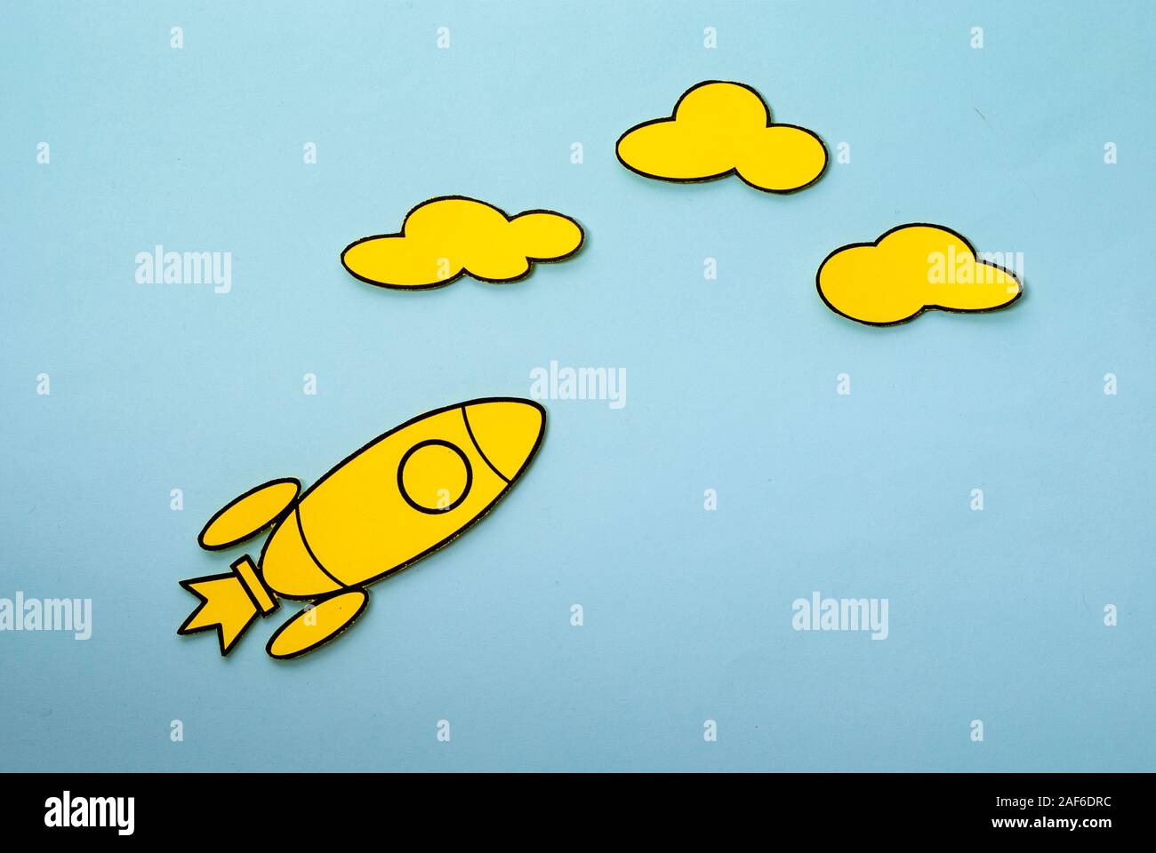 Little yellow rocket flying high aiming for clouds Stock Photo - Alamy