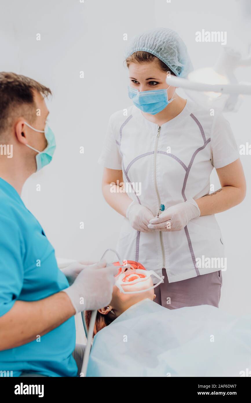 Dentist performs teeth cleaning procedure hi-res stock photography and ...