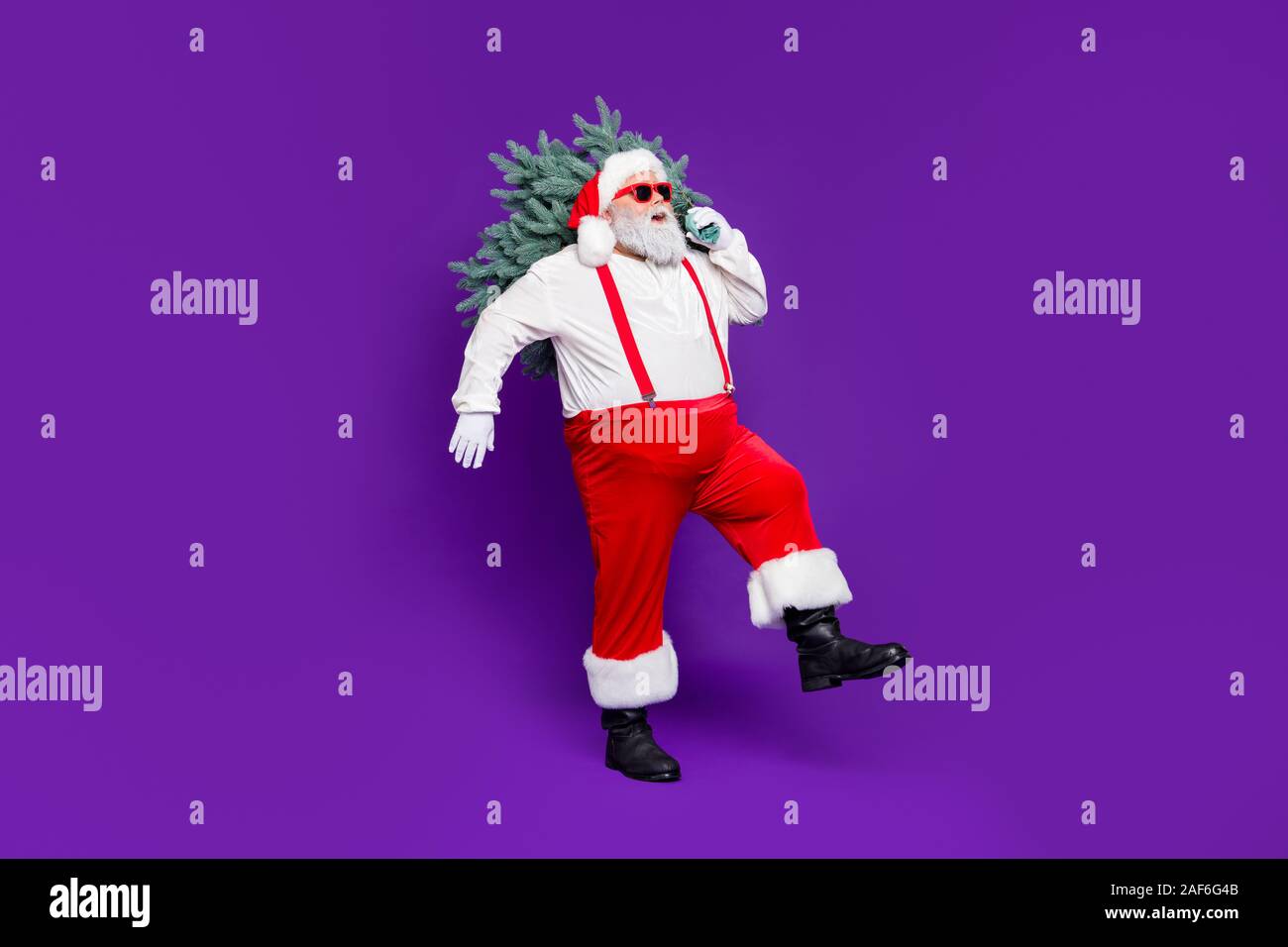 Full length photo of funny fat santa father holding x-mas tree on ...