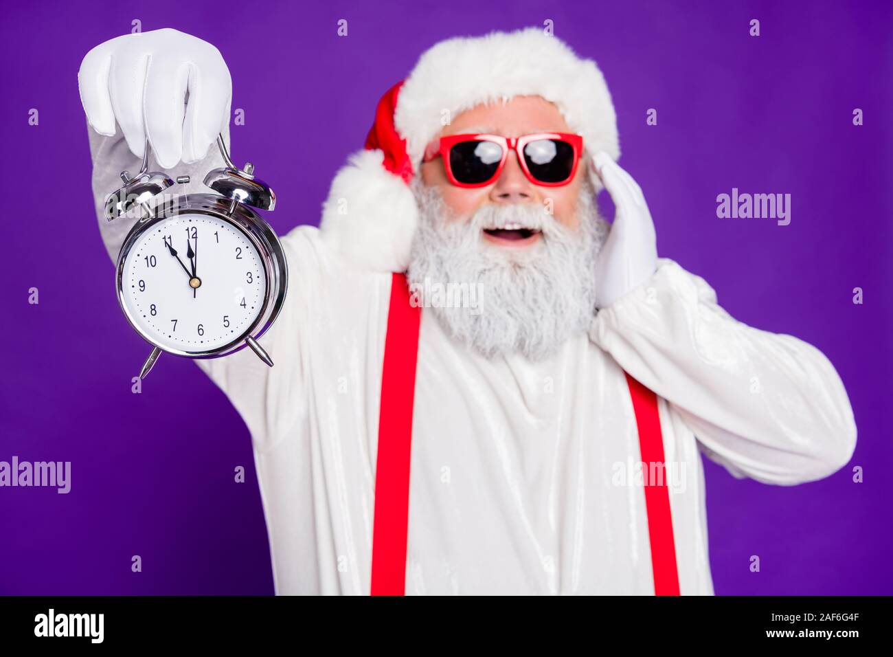 Photo of funny overweight santa father holding alarm clock remind it's ...