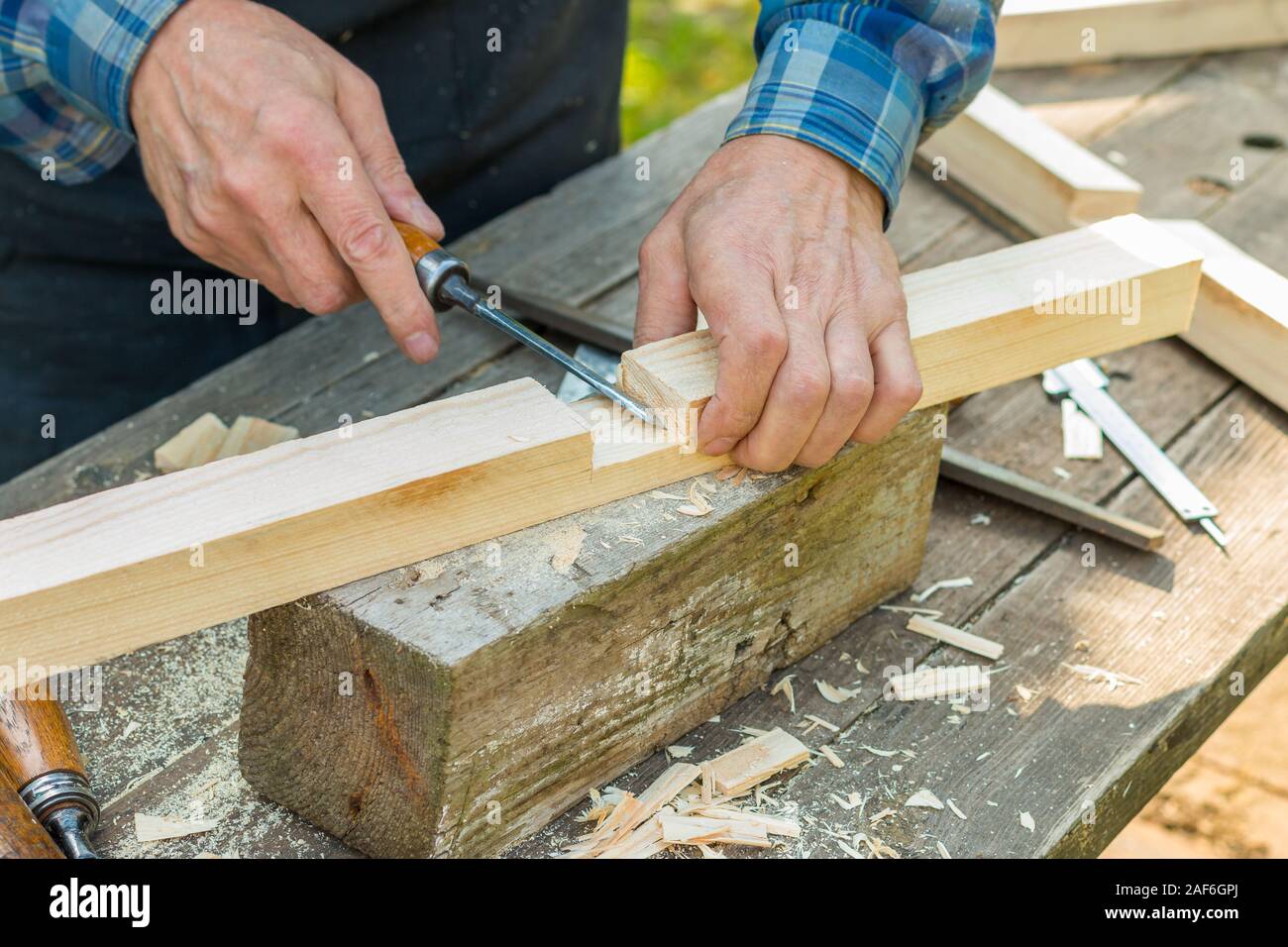 a senior carpenter working with wood outdoors during sunny day Stock ...