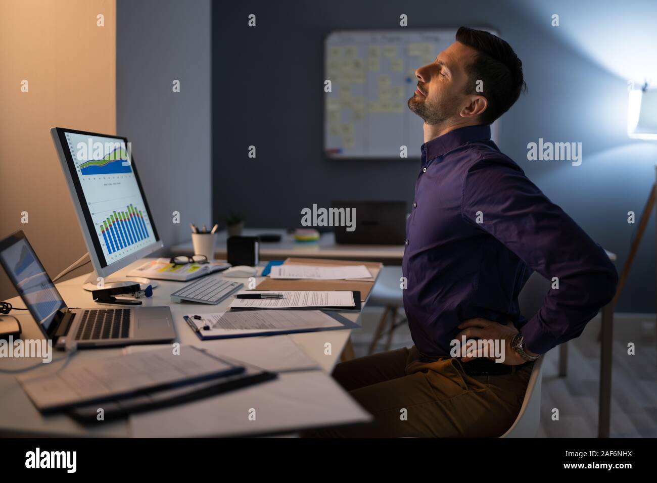 Young Businessman Having Back Pain While Sitting At Office Desk Stock ...