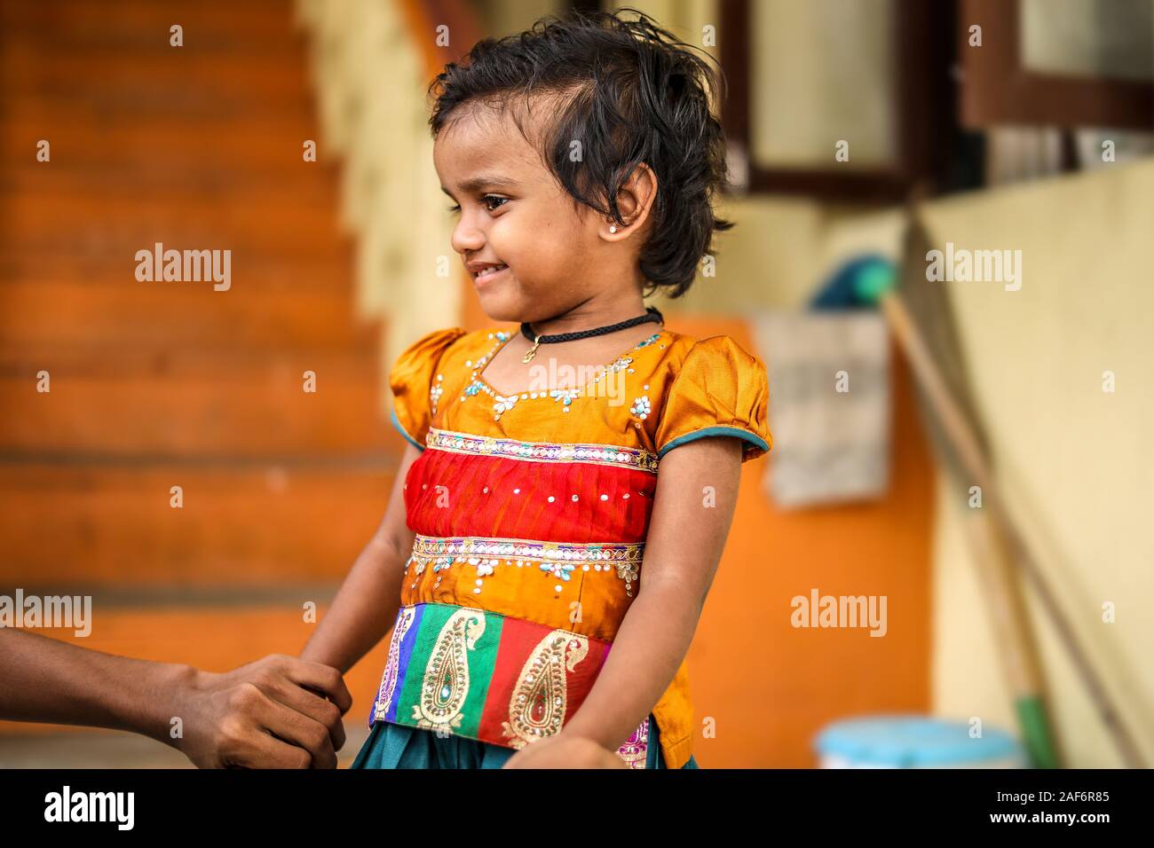 child little girl standing at home against stairs Stock Photo - Alamy