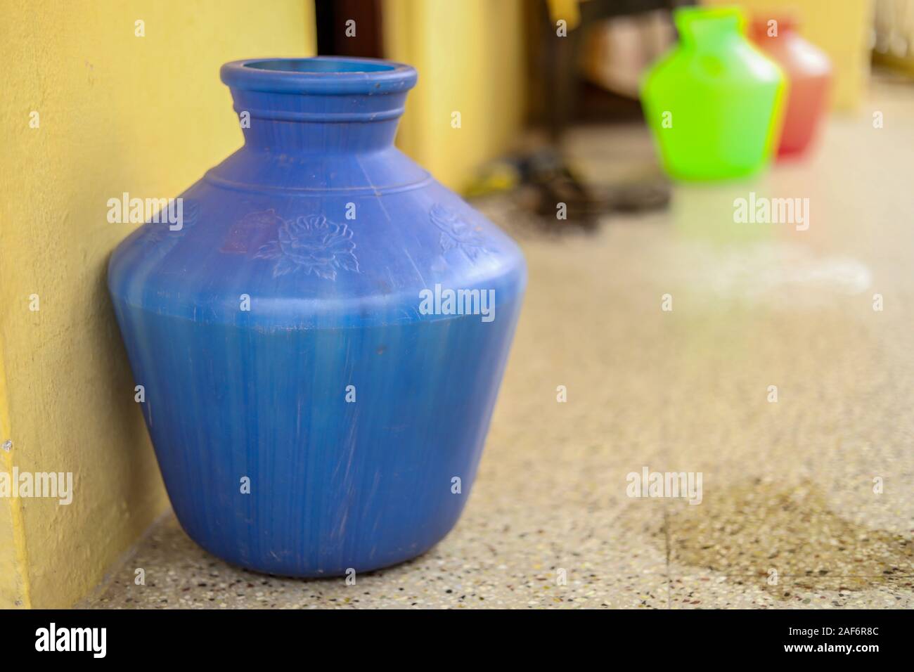 Blue plastic water pitcher in front of houses Stock Photo - Alamy