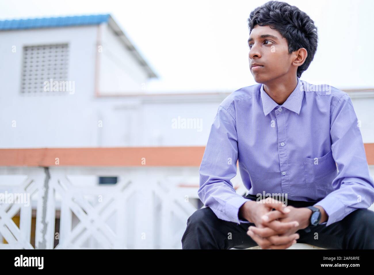 Portrait of smart young man sitting on stool. Attractive male model ...