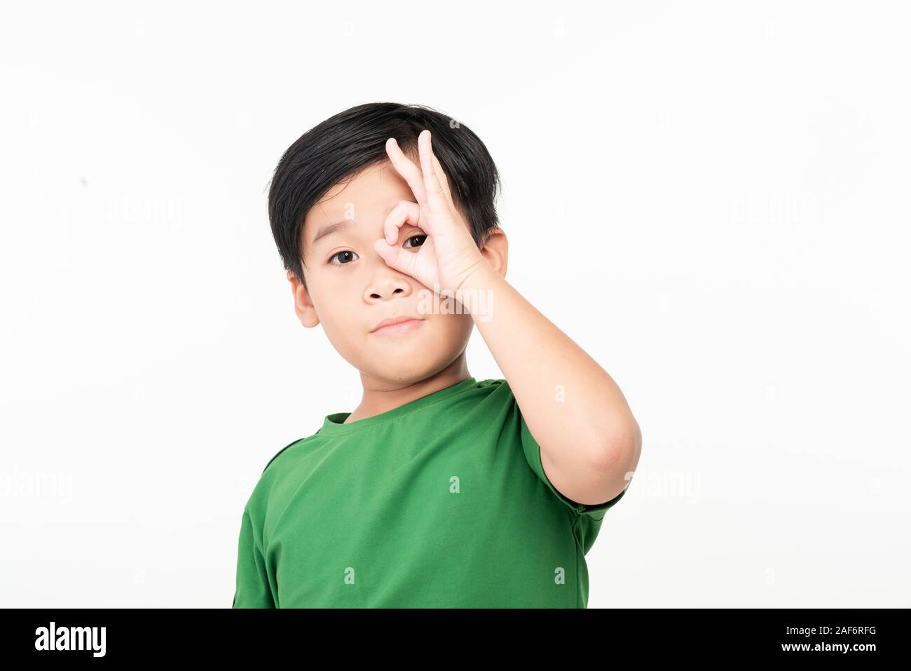 Dark haired little child with happy face smiling doing ok sign with ...