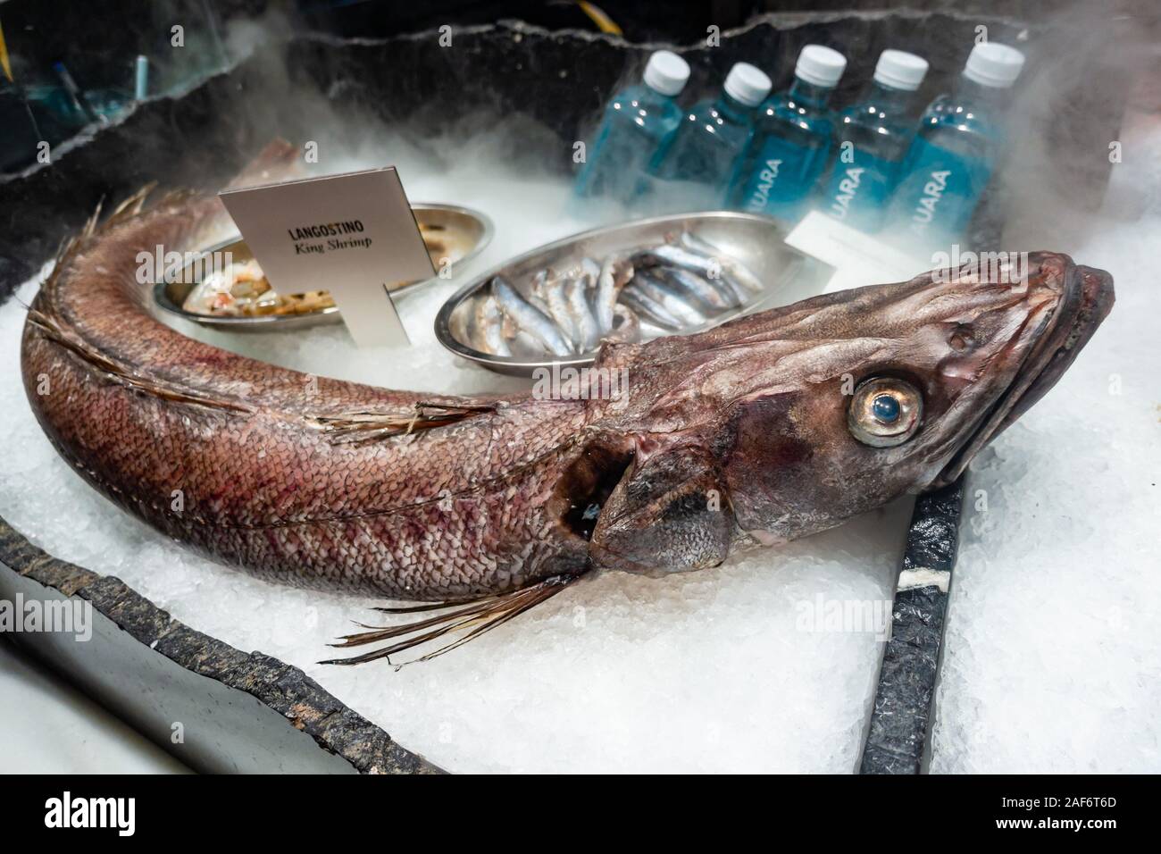 Fresh whole hake fish on ice on a market stall in Mercado San Miguel in ...