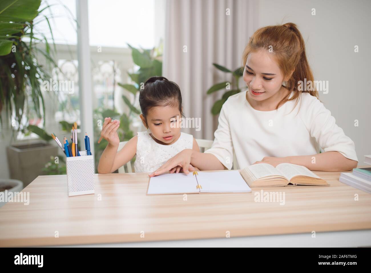 Mother helping her little child with homework Stock Photo - Alamy