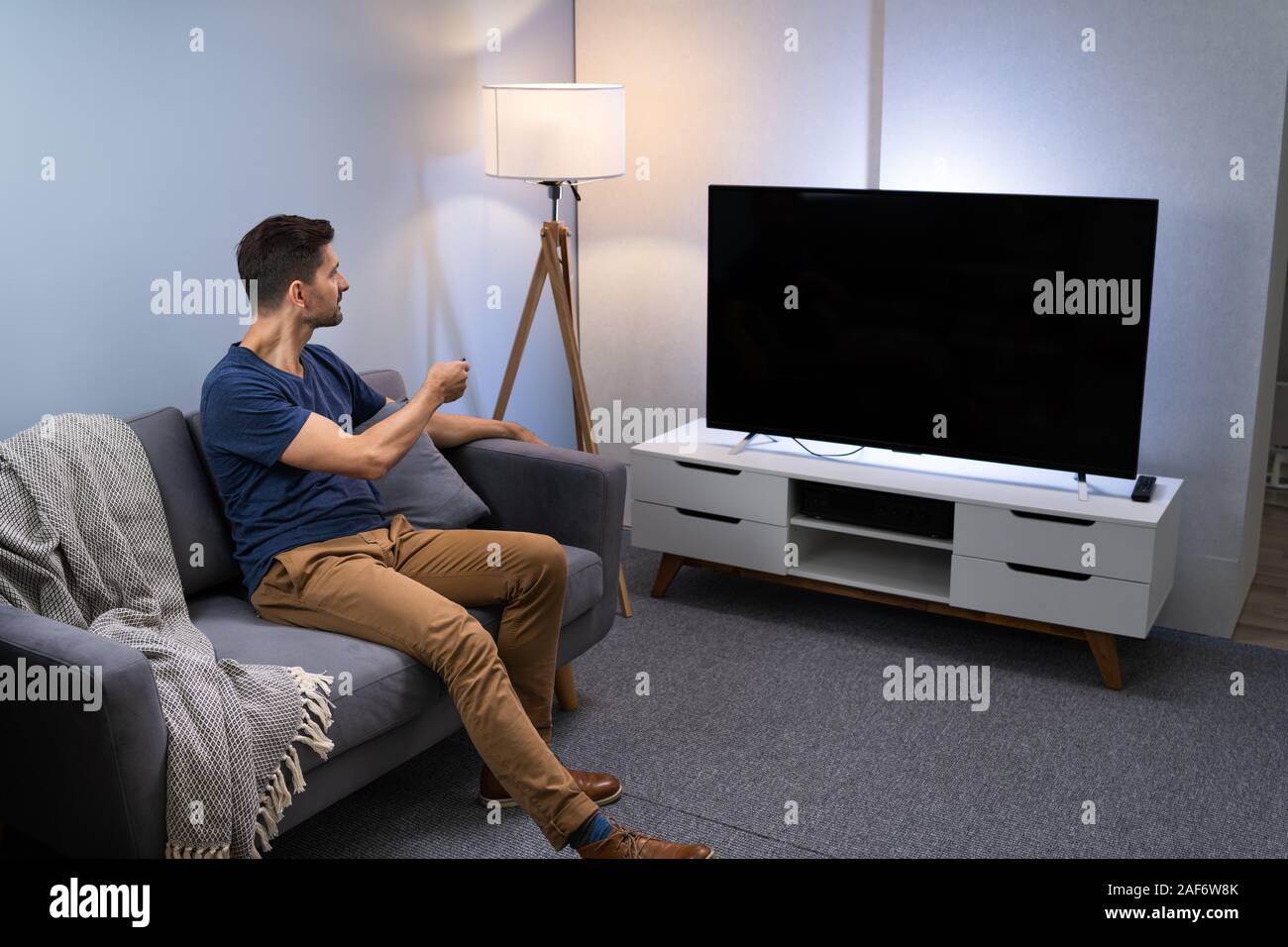 Person Controlling Smart Light With Remote Control Stock Photo - Alamy