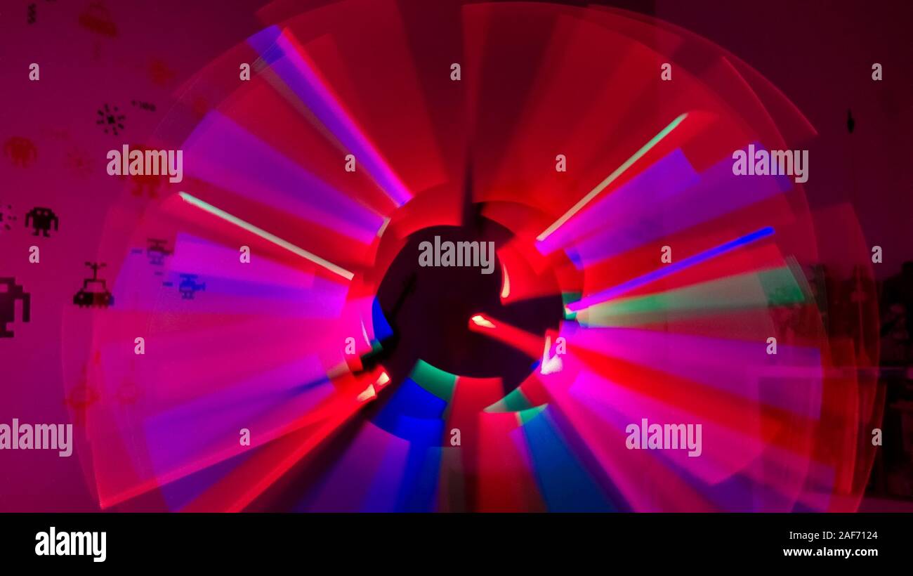 Boy playing in his room with lightsaber in various colors with figures ...