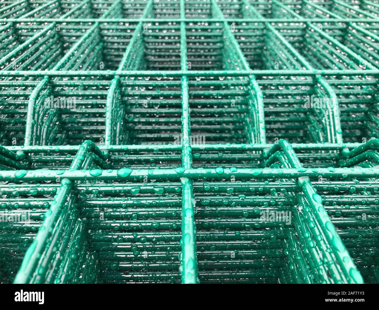 Rain drops on green colored metal grid Stock Photo - Alamy
