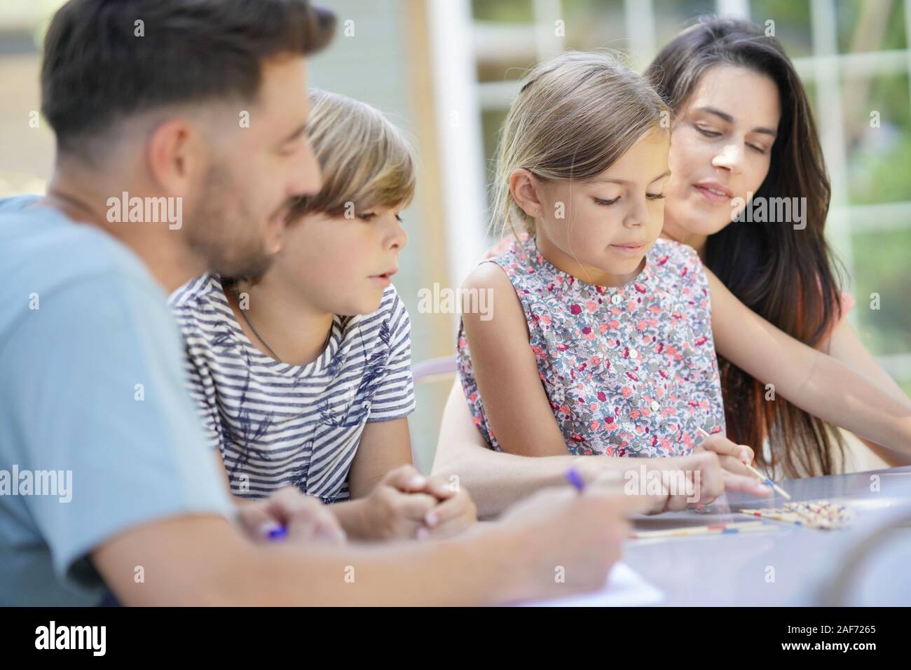 Happy family enjoying playing game together Stock Photo - Alamy
