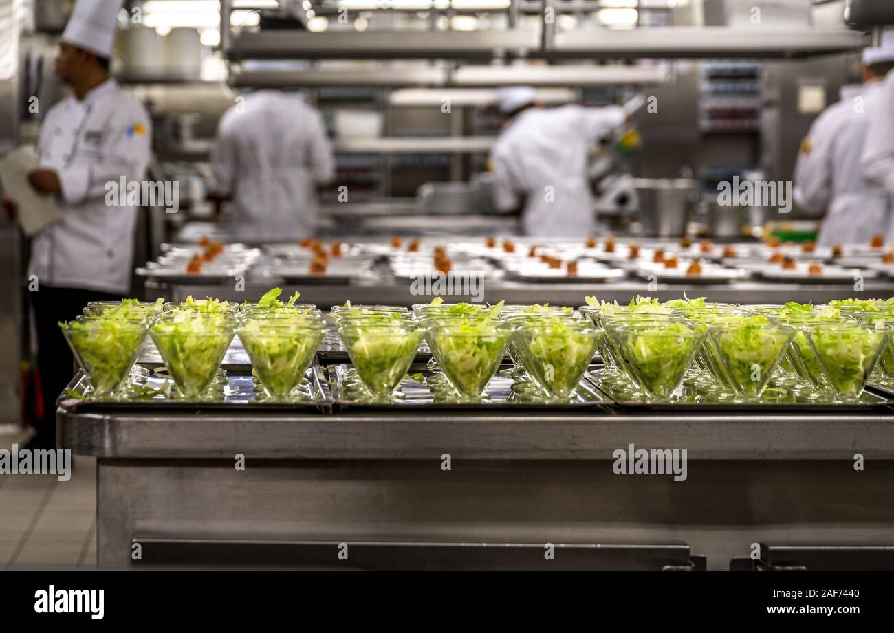 A helper prepares salad bowls with shrimps for the passengers in a ...