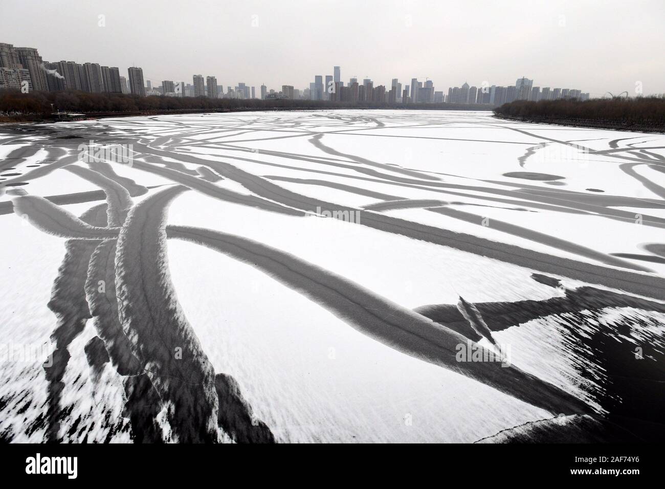 View of the snow-covered frozen Hunhe River with lines and signs on the ...