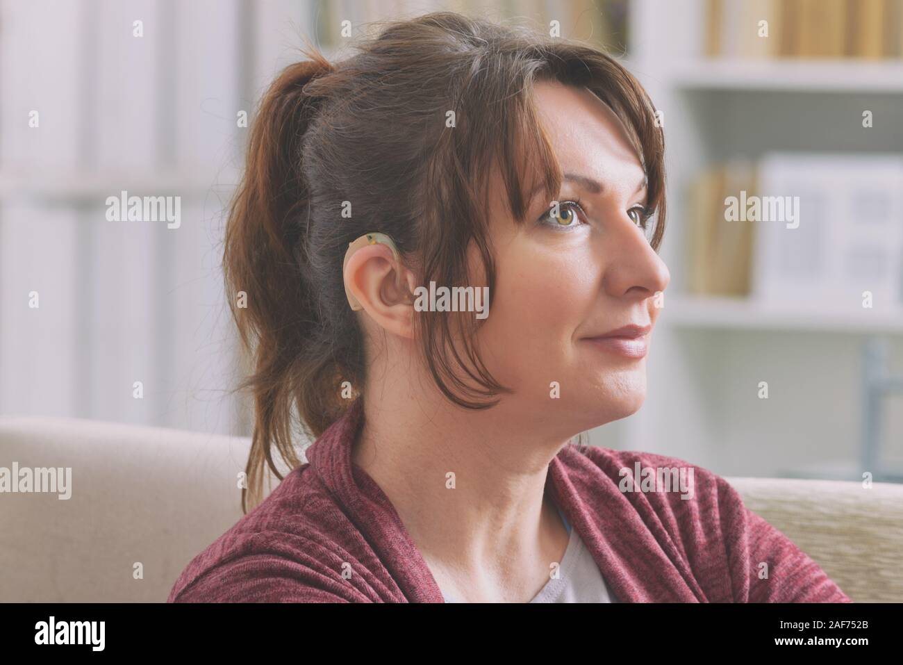 Smiling deaf woman wearing hearing aid Stock Photo - Alamy