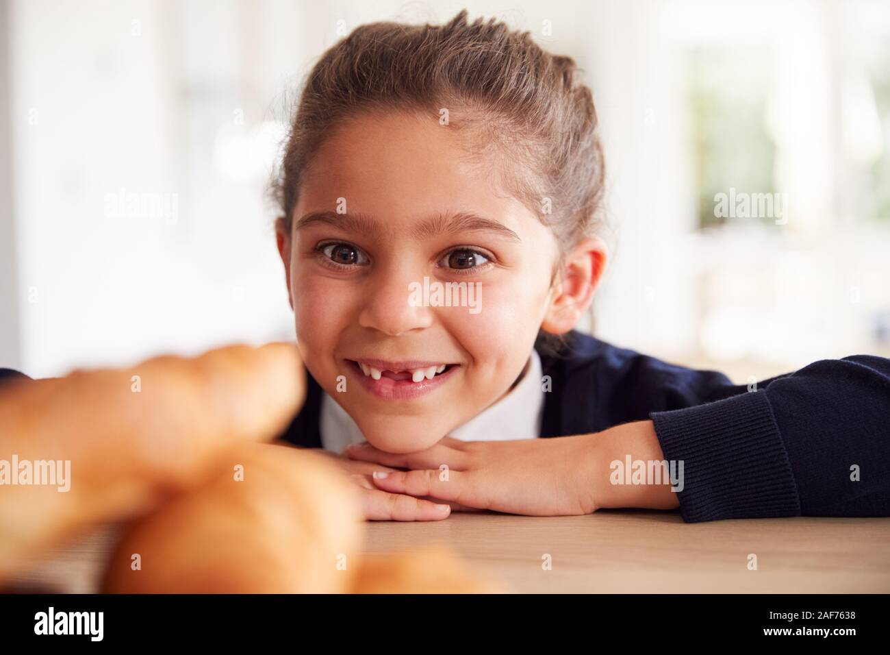Mischievous Girl Wearing School Uniform Taking Croissant From Kitchen ...