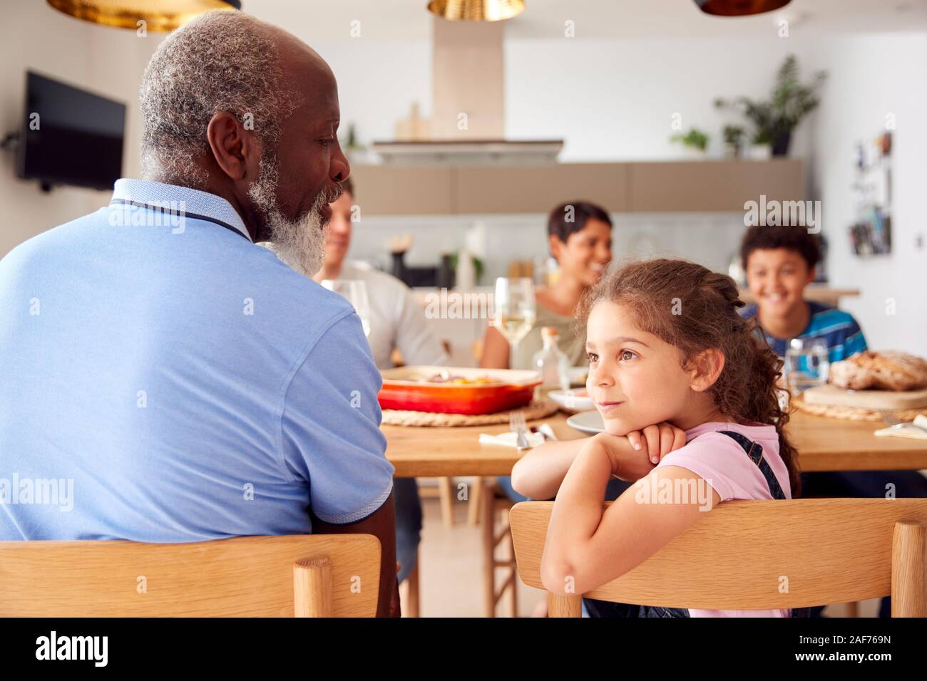 Multi-Generation Mixed Race Family Eating Meal Around Table At Home ...