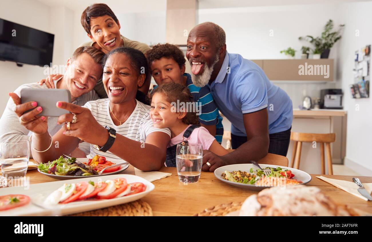 Multi-Generation Mixed Race Family Posing For Selfie As They Eat Meal ...