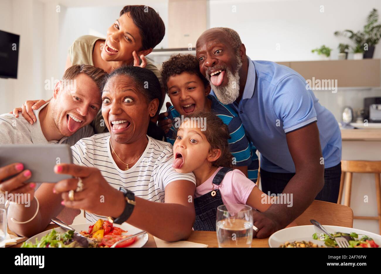 Multi-Generation Mixed Race Family Posing For Selfie As They Eat Meal ...